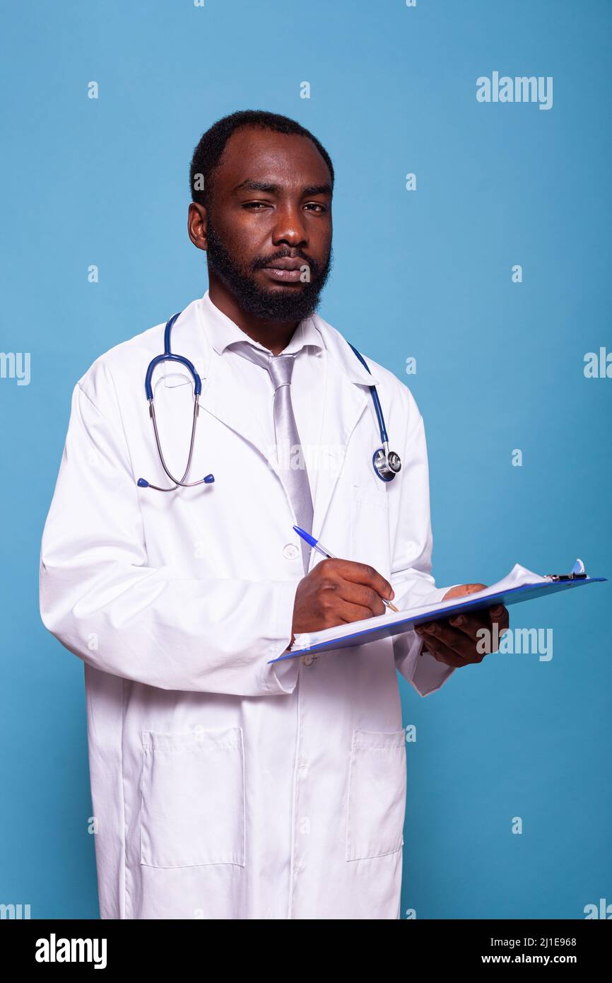 Doctor writing in patient chart hi-res stock photography and images - Alamy