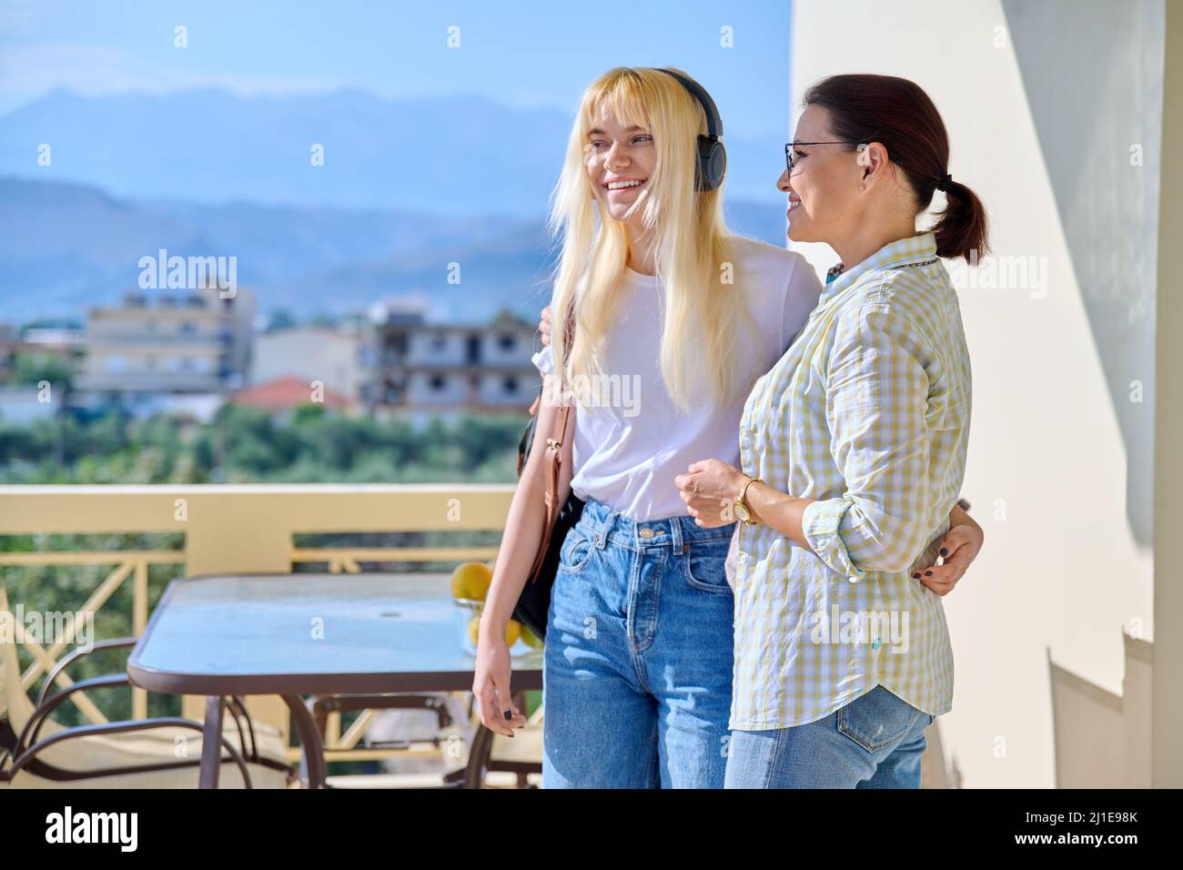 Middle-aged mother hugging her teenage daughter on the porch of the house Stock Photo - Alamy
