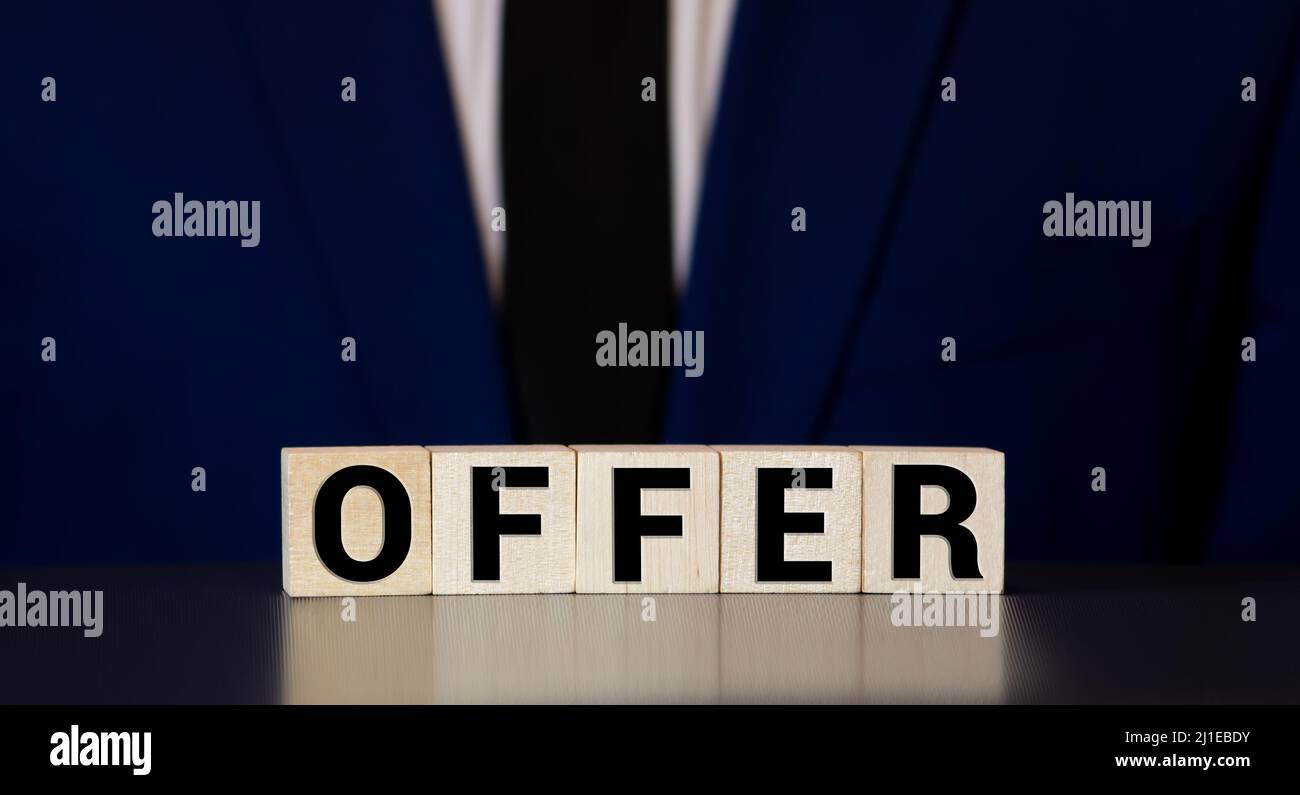 Word OFFER is made of wooden building blocks lying on the table and on ...