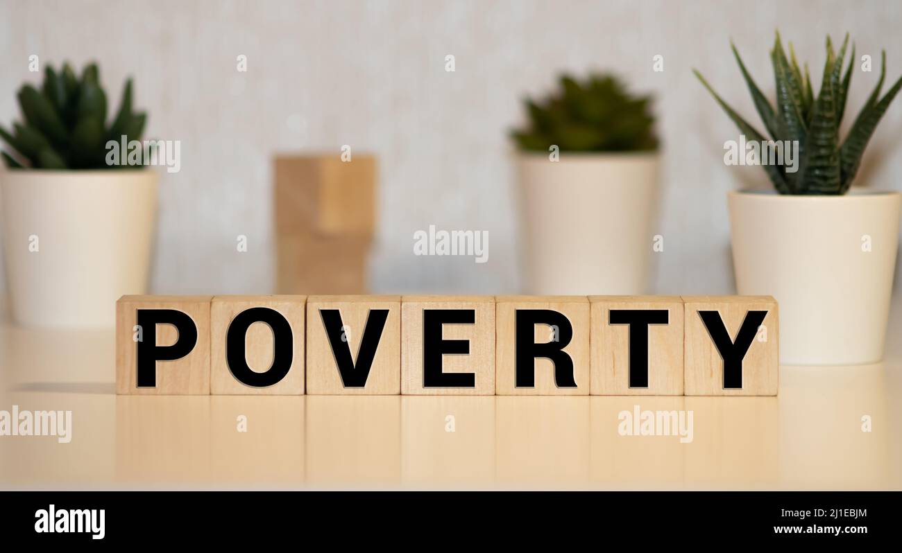 Poverty word written on wood block. Poverty text on wooden table for ...