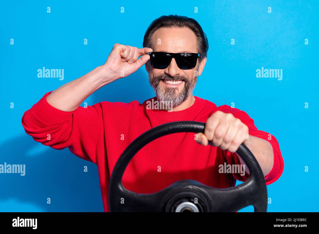 Portrait of cheerful handsome confident automobile driver practicing ...