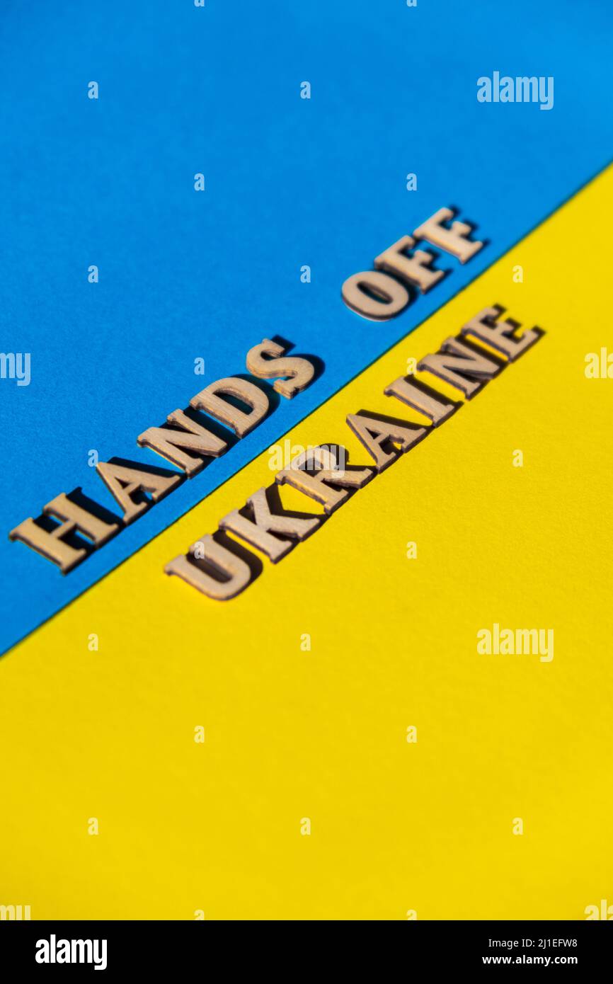 Ukrainian national flag made of paper. HANDS OFF UKRAINE text. Stop War ...