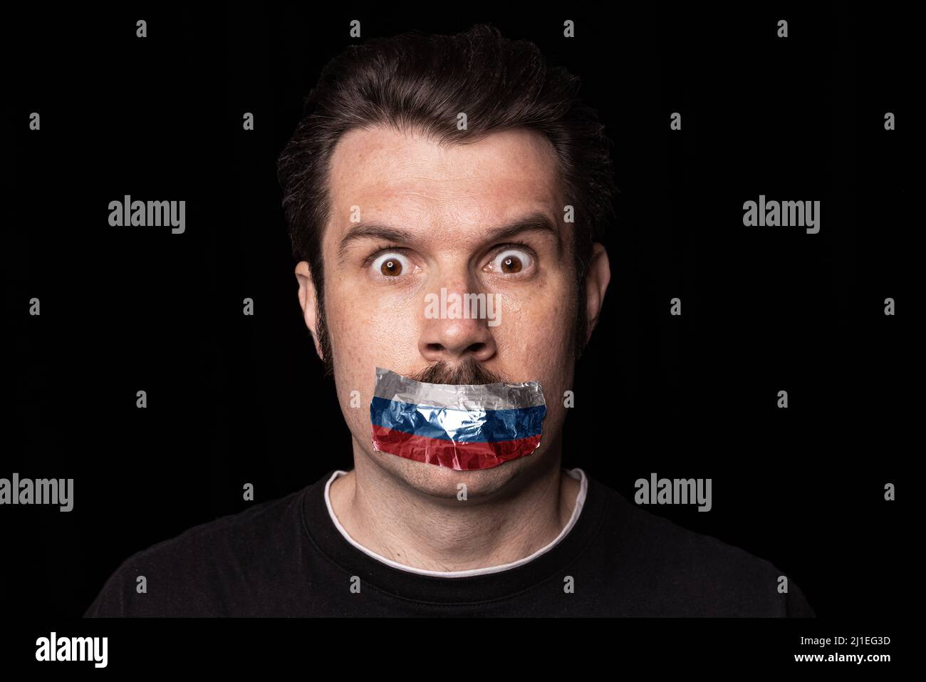 Conceptual portrait of young man with three colors duct tape over his ...