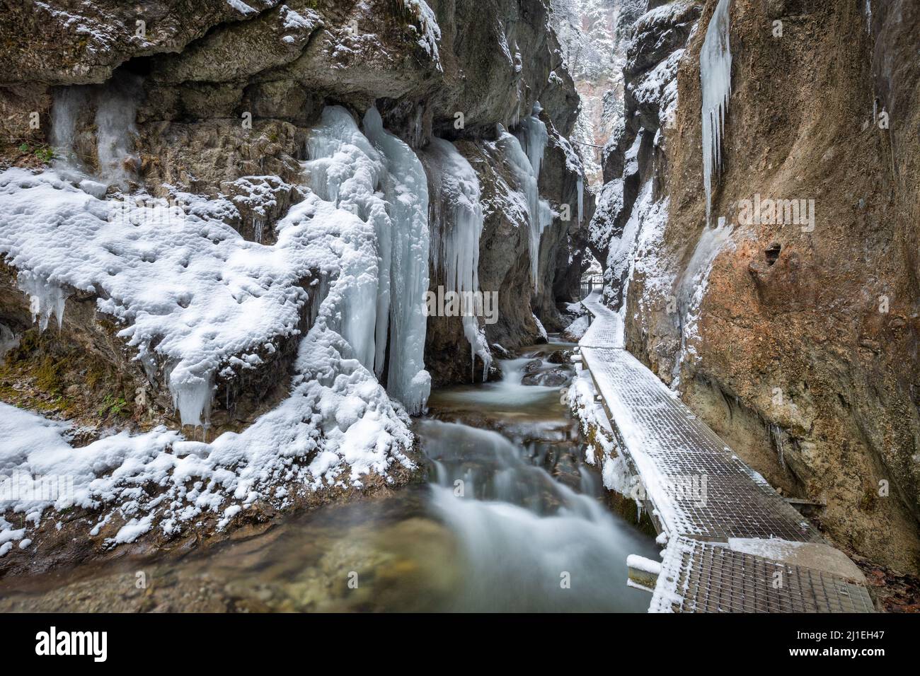 Winter landscape with a wild stream and waterfalls through a narrow ...