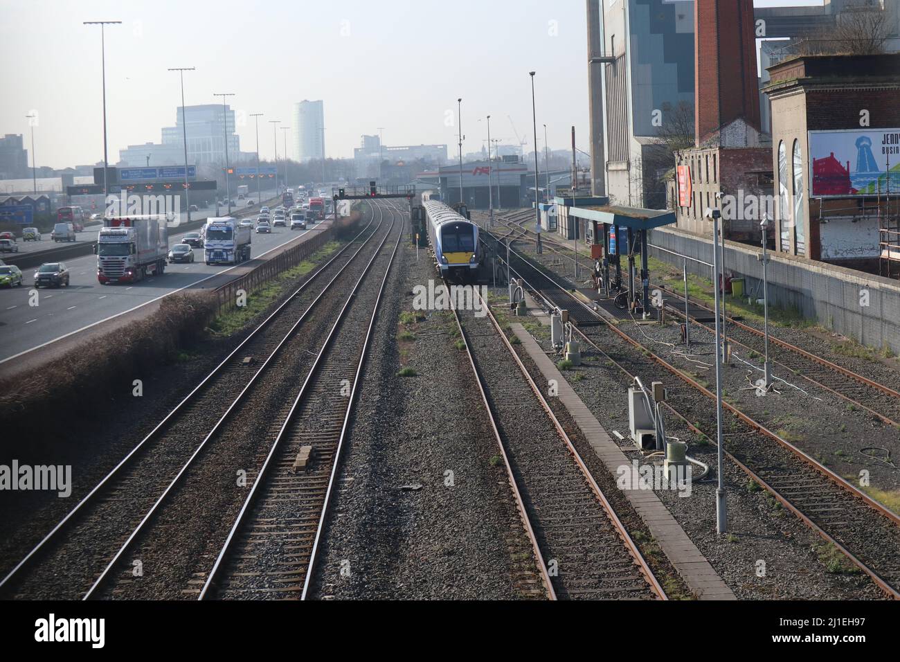 A train running parallel to a motorway Stock Photo - Alamy