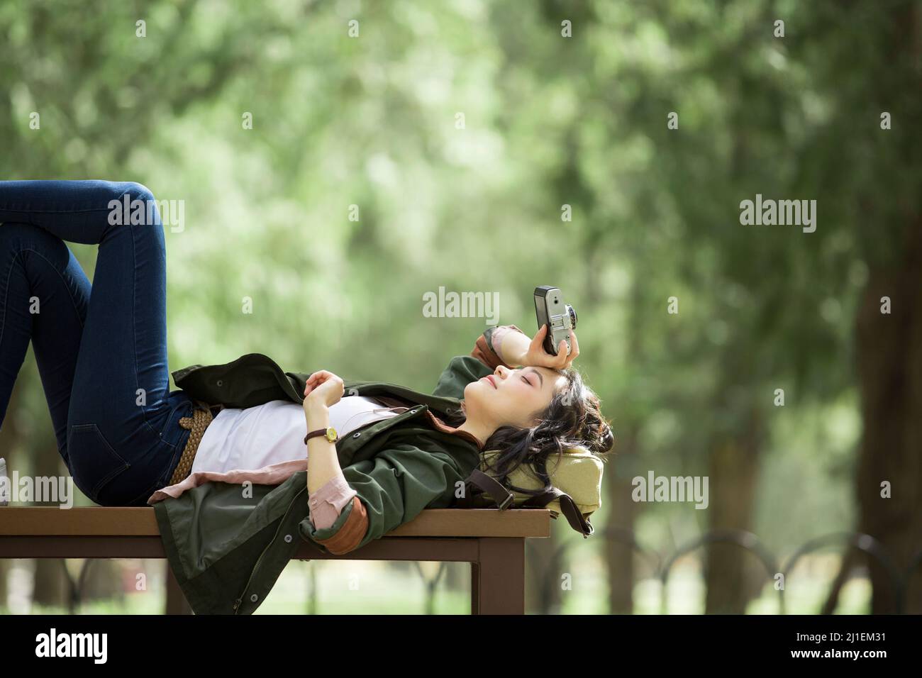 Young female photographer lying and resting on bench - stock photo ...