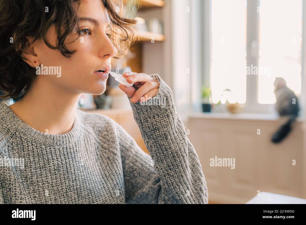 Collection of saliva test for coronavirus at home. teenage girl is ...