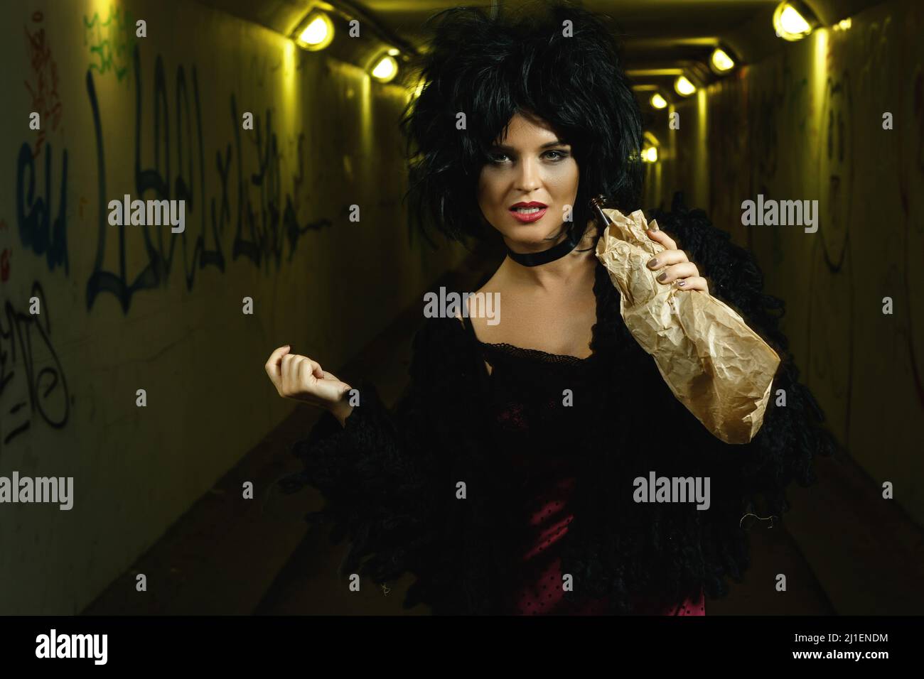 Freaky woman with a bottle of alcohol in the paper bag Stock Photo - Alamy