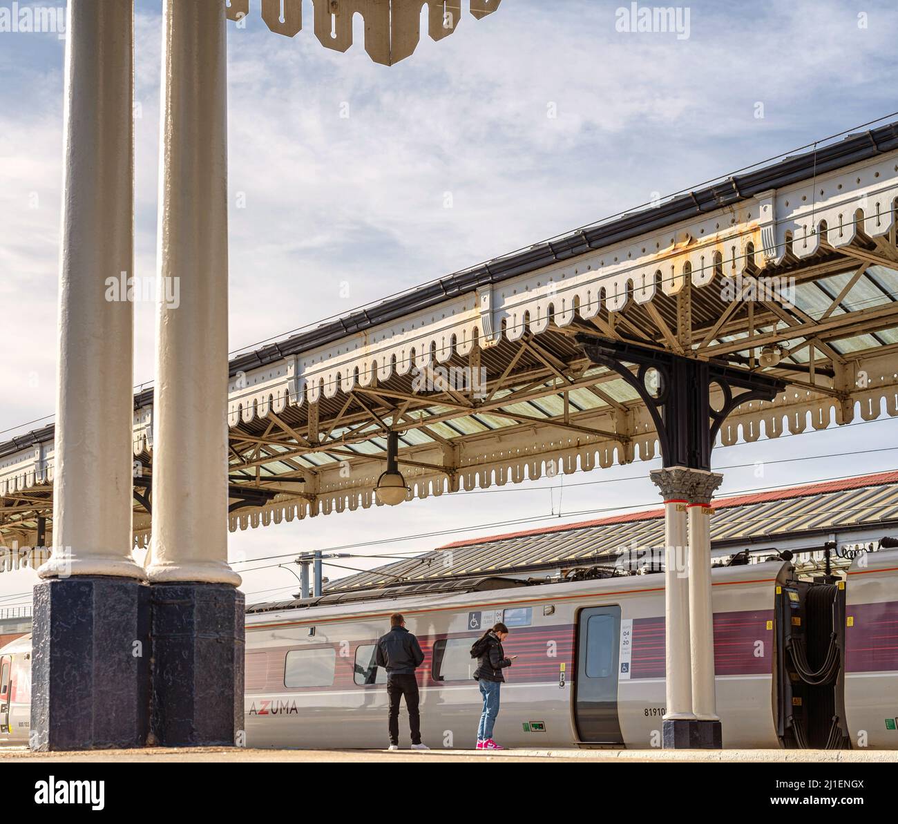 Railway station platform with a train carriage . Overhead is an ...