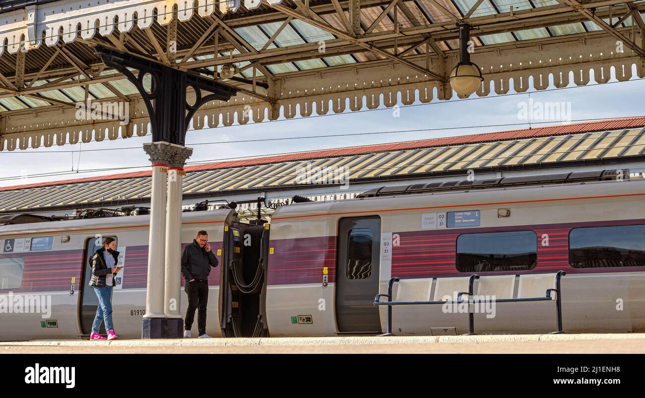 Railway station platform with a train carriage . Overhead is an ...