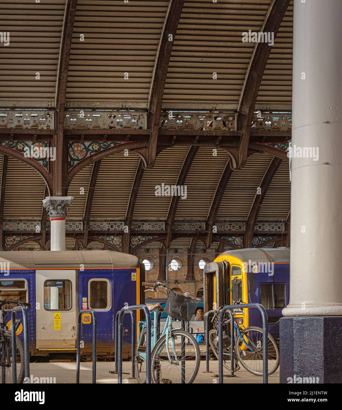 Railway station platform with a bicycle in the foreground. Two trains ...