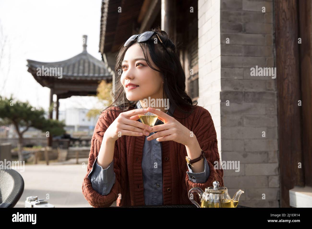 Chinese college student enjoying afternoon tea in sidewalk cafe - stock ...