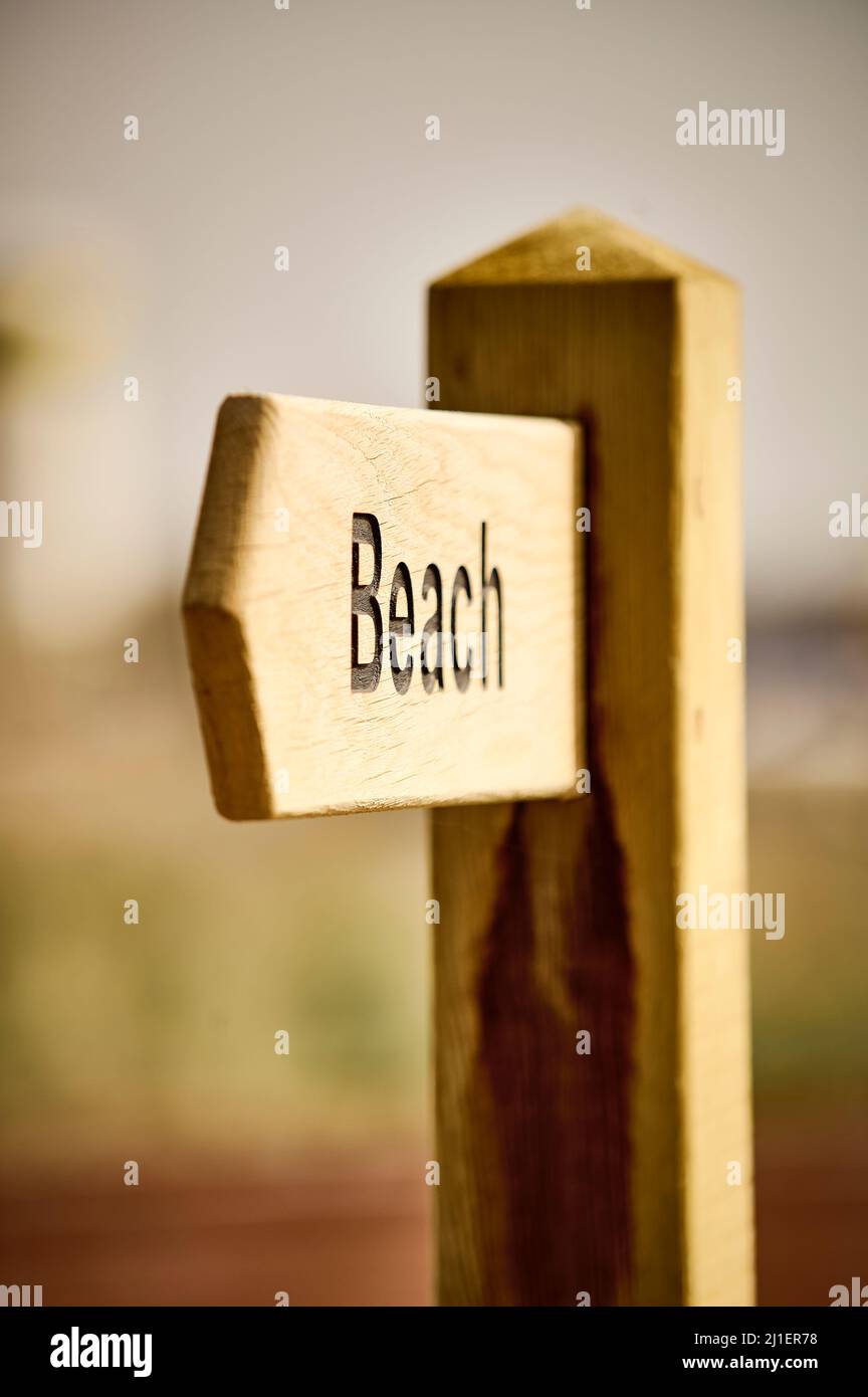 Wooden sign pointing to the beach Stock Photo - Alamy