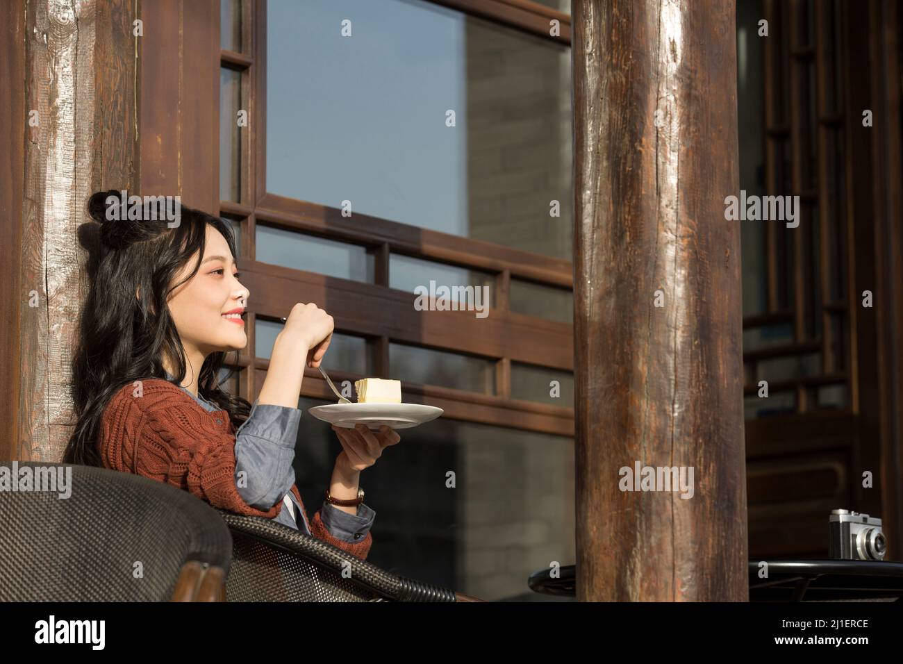 Chinese college student enjoying afternoon tea in sidewalk cafe - stock ...