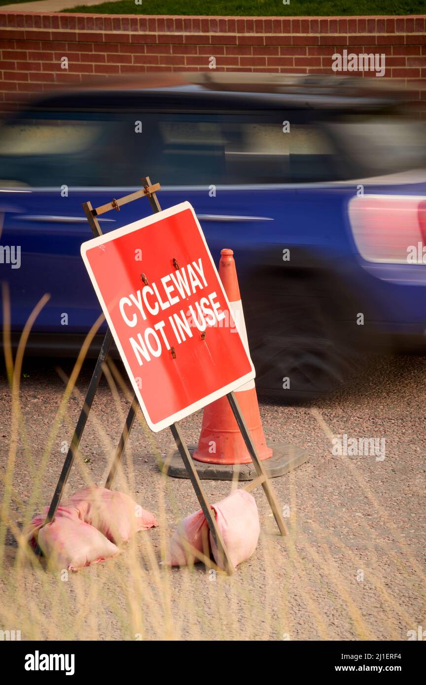 Cycleway not in use sign on road next to speeding car Stock Photo - Alamy