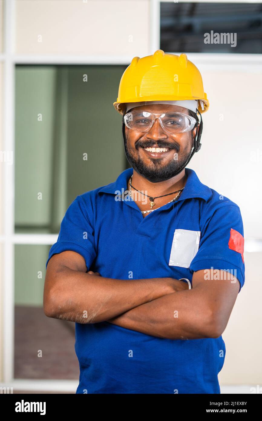 construction worker with safety helmet and eye glasses standing with ...