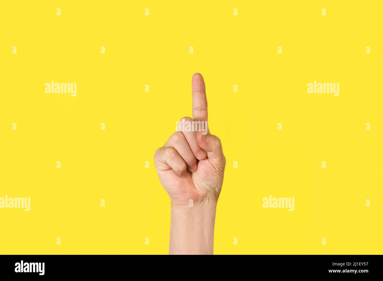 Man hand doing number one gesture on a yellow background with copy ...