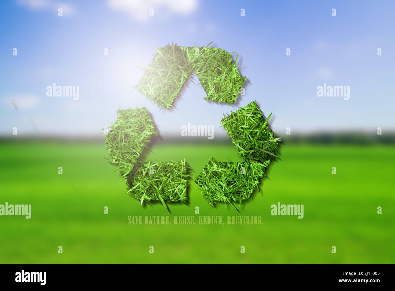 Recycling sign created from grass. Blurred landscape in the background ...