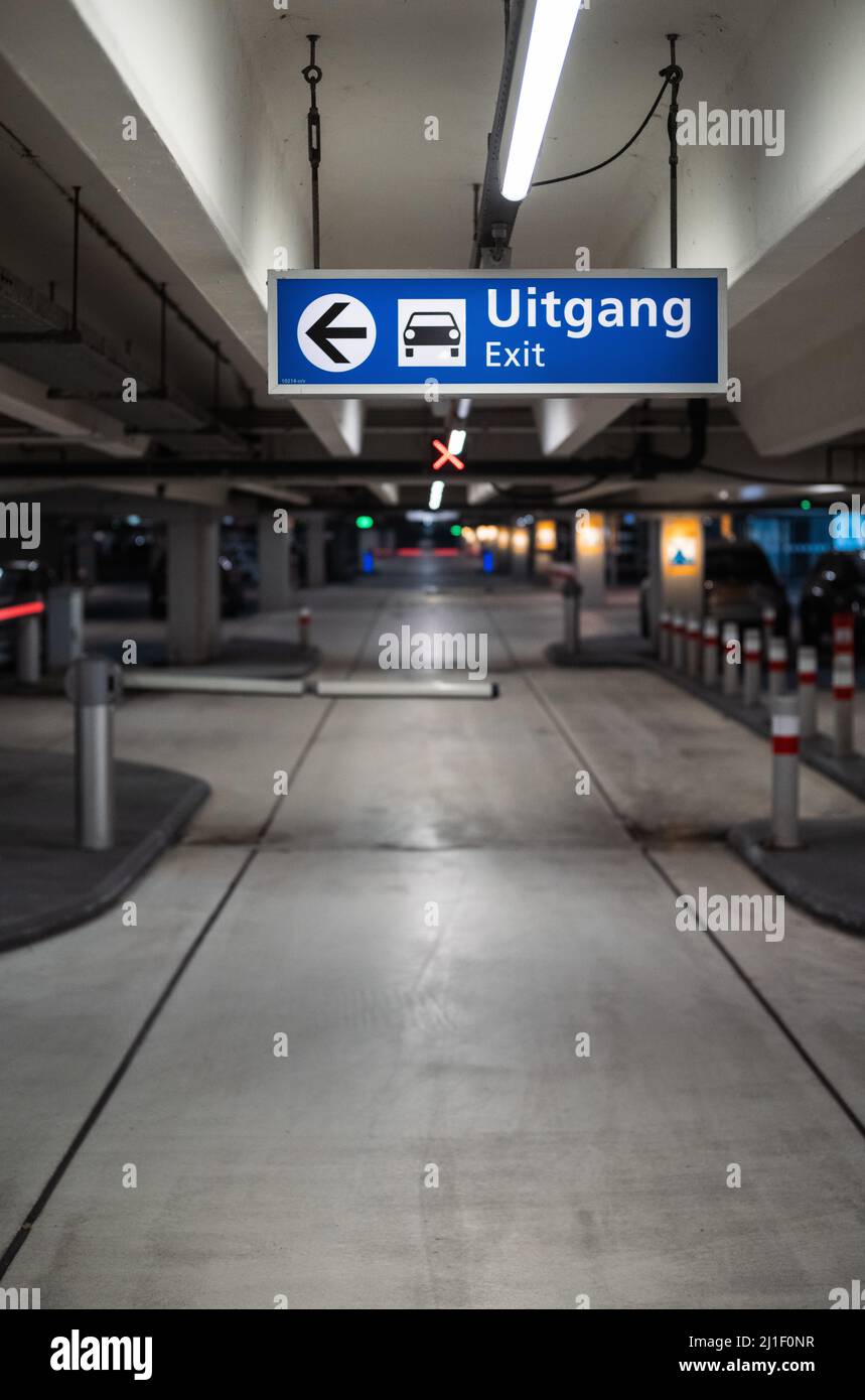 A vertical shot of an exit sign in a car parking lot of an airport in ...
