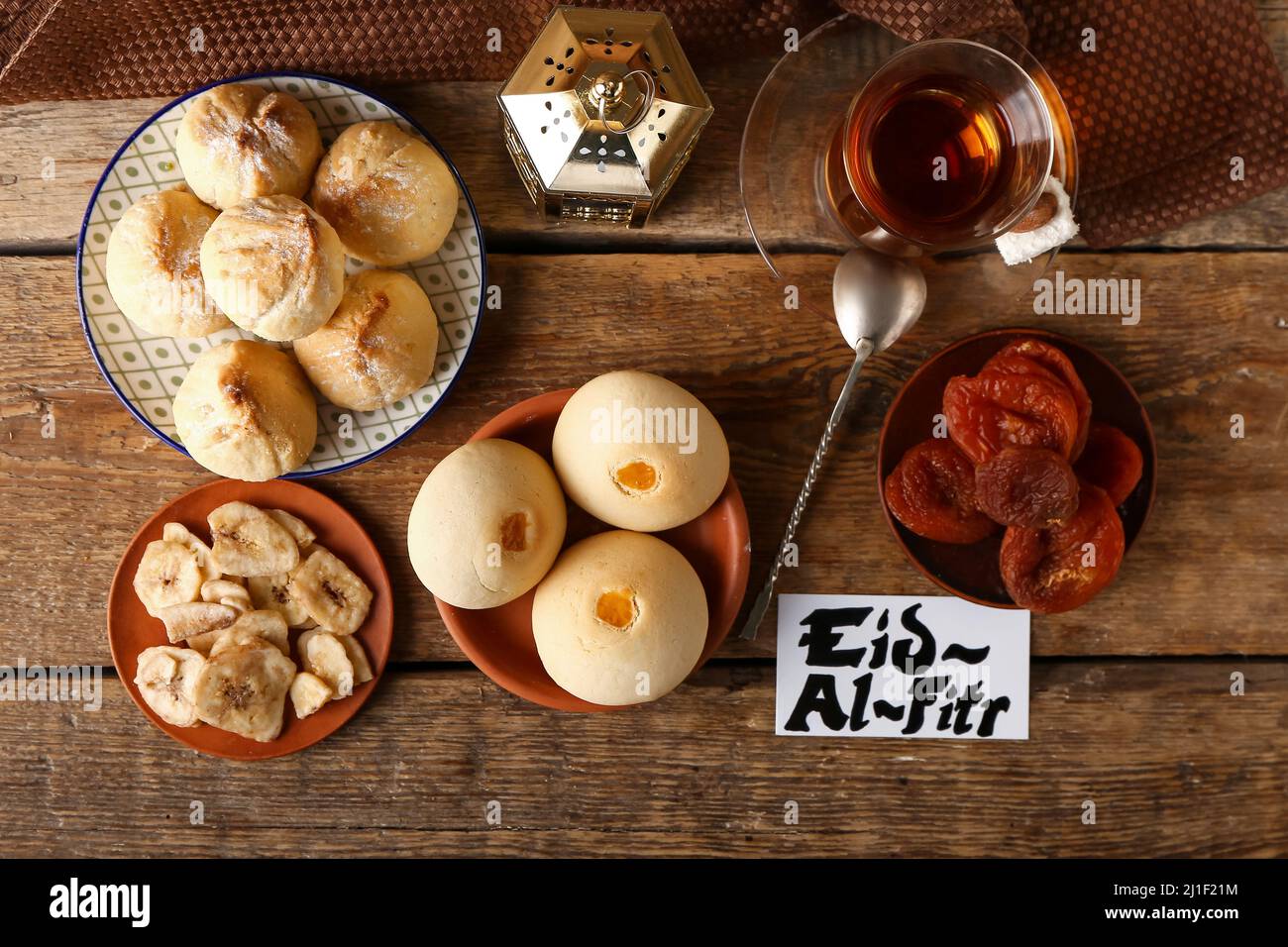 Tasty Eastern sweets with tea and greeting card for Eid al-Fitr (Feast ...