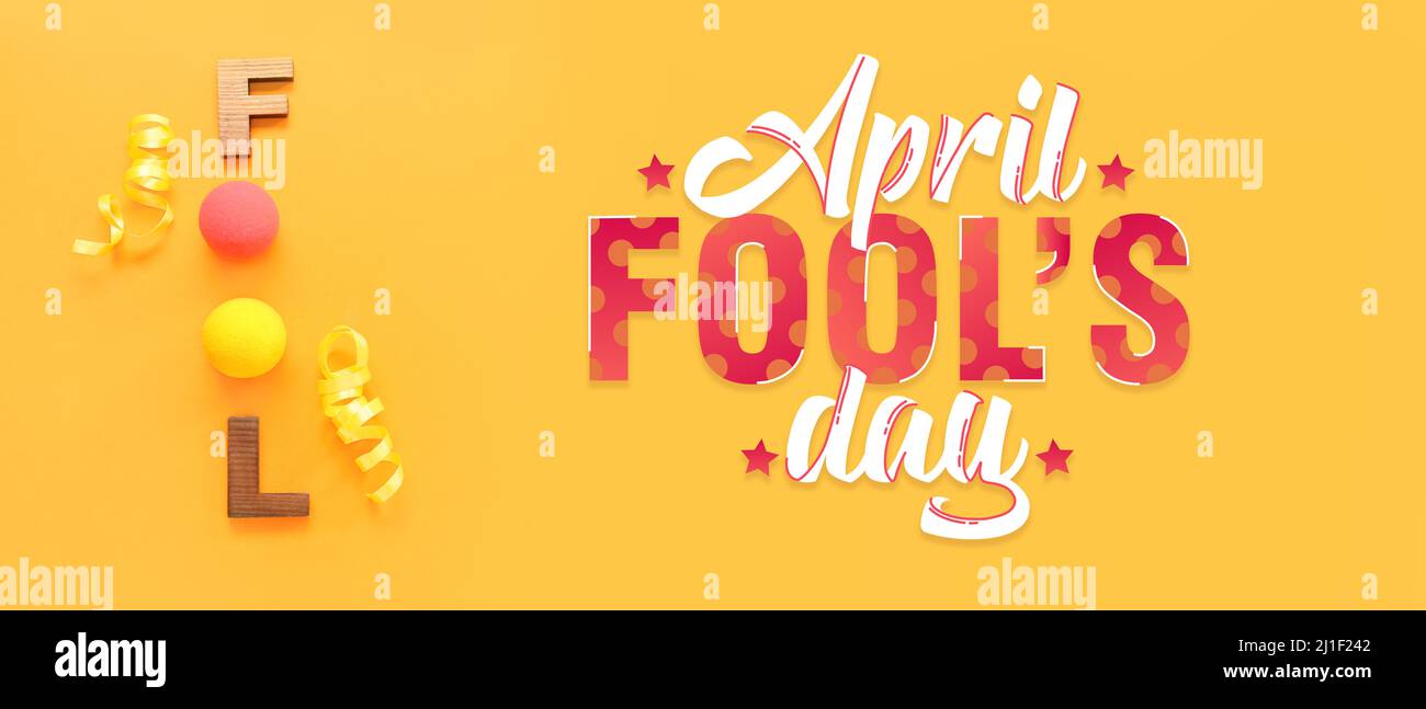 Word FOOL made of clown noses, letters and confetti on orange ...