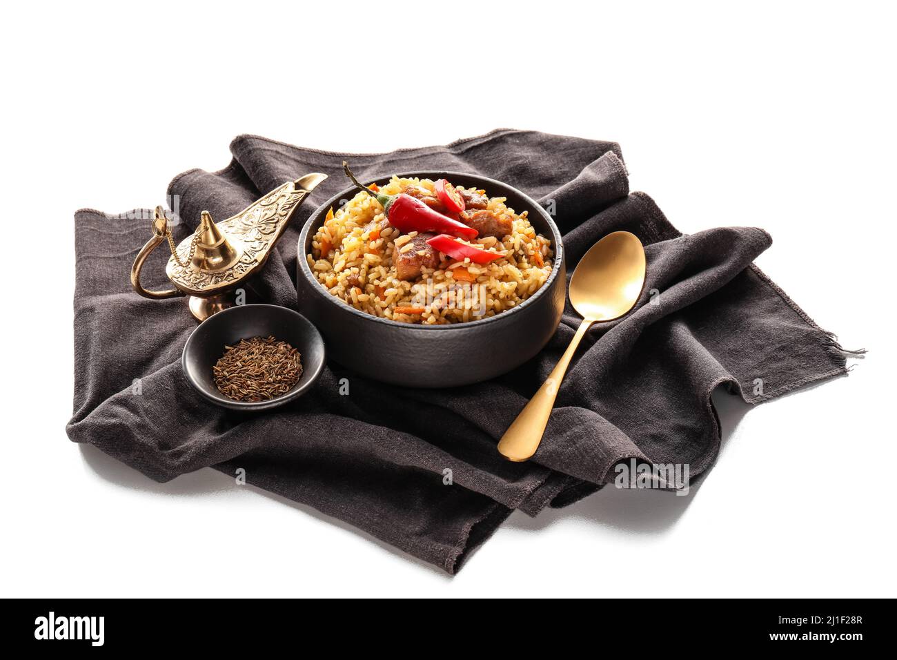 Bowl of traditional pilaf and Aladdin lamp on white background Stock ...