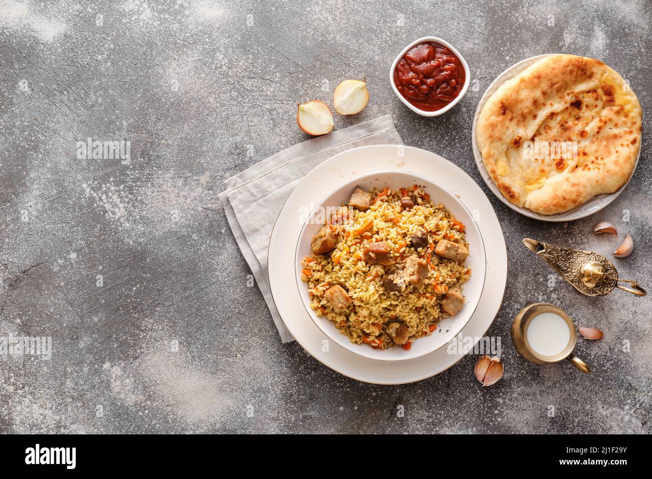 Plate of traditional pilaf with flatbread and Aladdin lamp on grunge ...