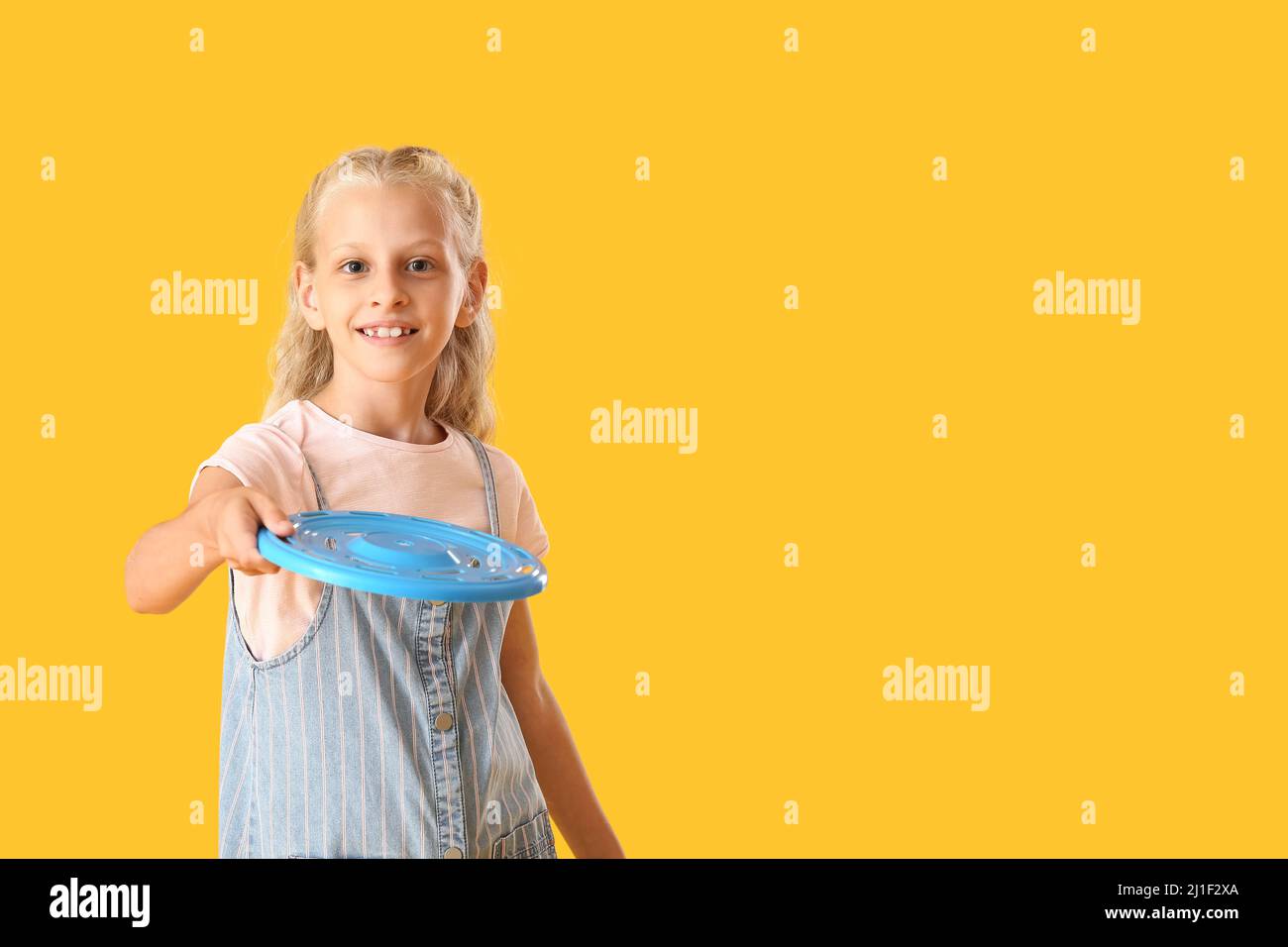 Funny little girl playing frisbee on color background Stock Photo - Alamy