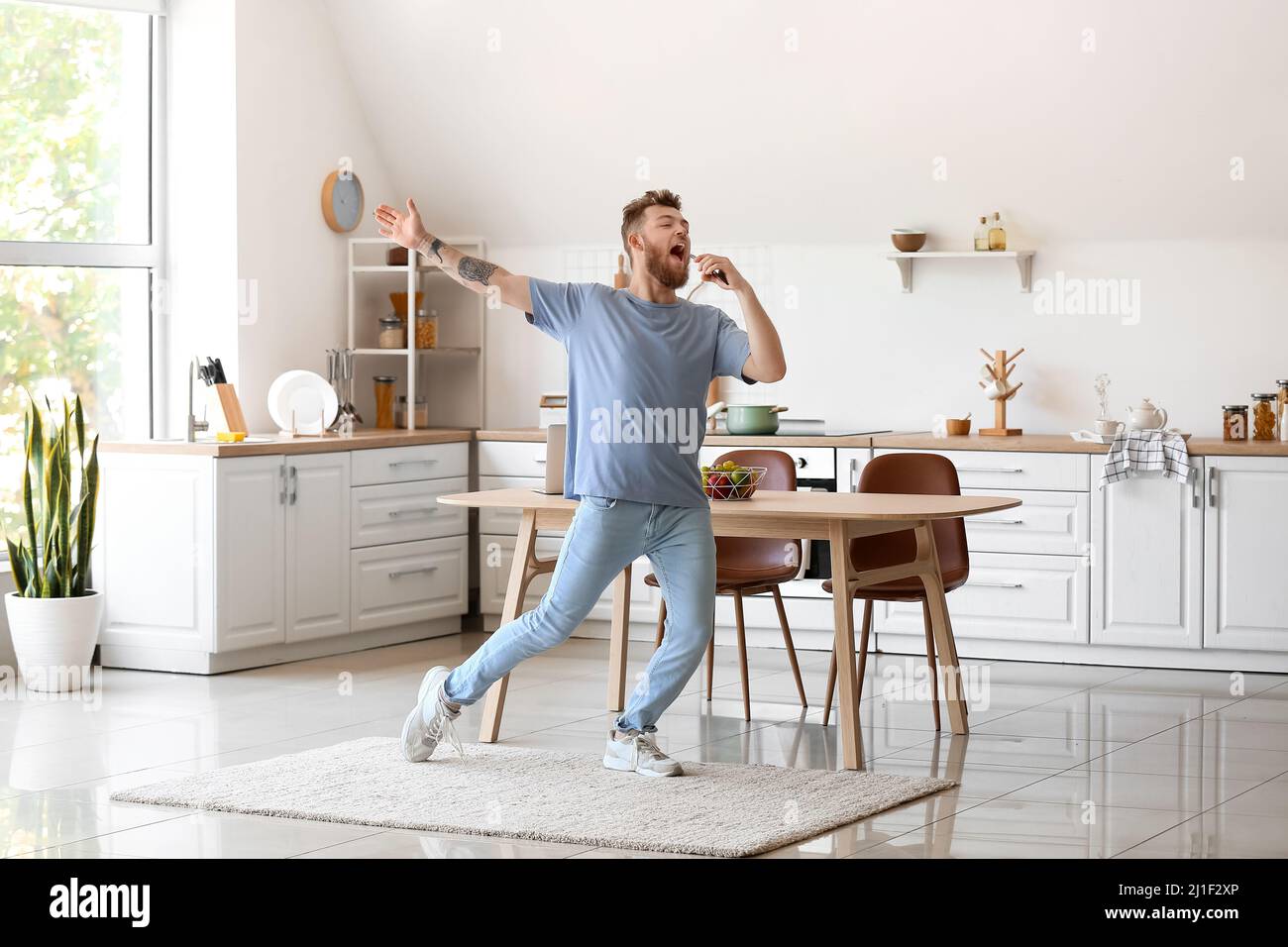Cool young man dancing and singing at home Stock Photo - Alamy
