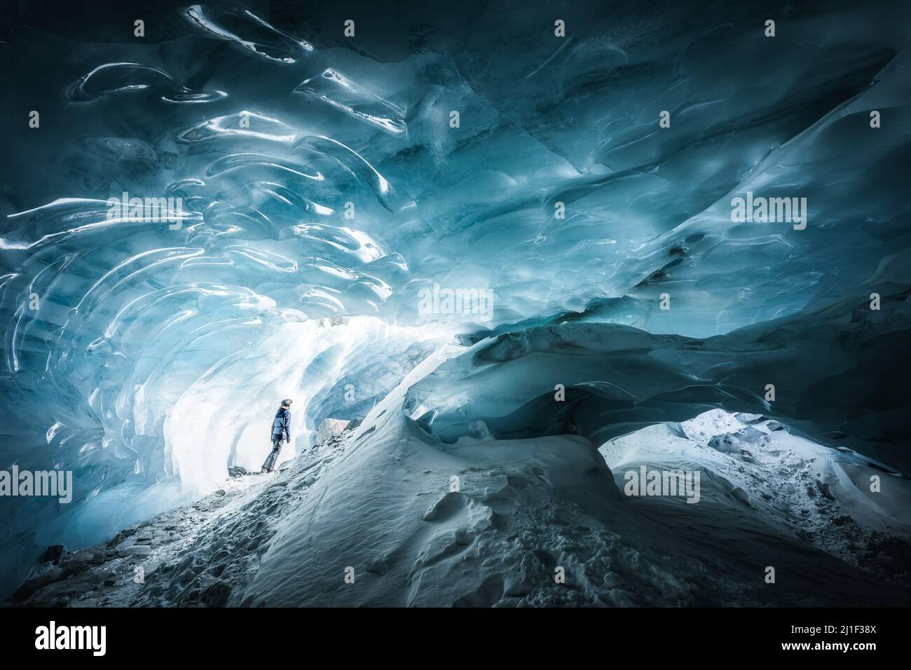 Silhouette of a person exploring a beautiful glacier ice cave in ...