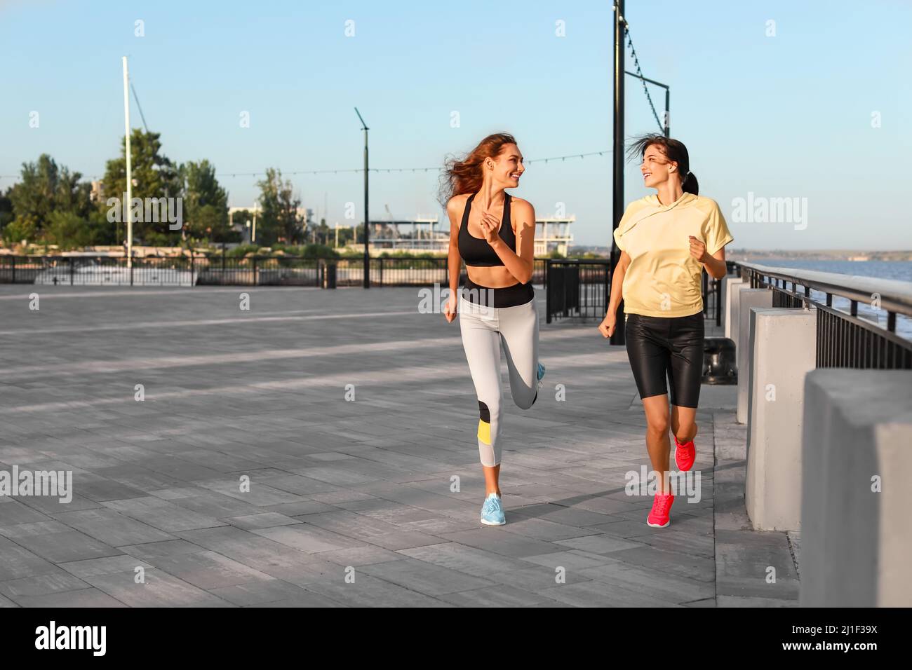 Beautiful young women running outdoors Stock Photo - Alamy