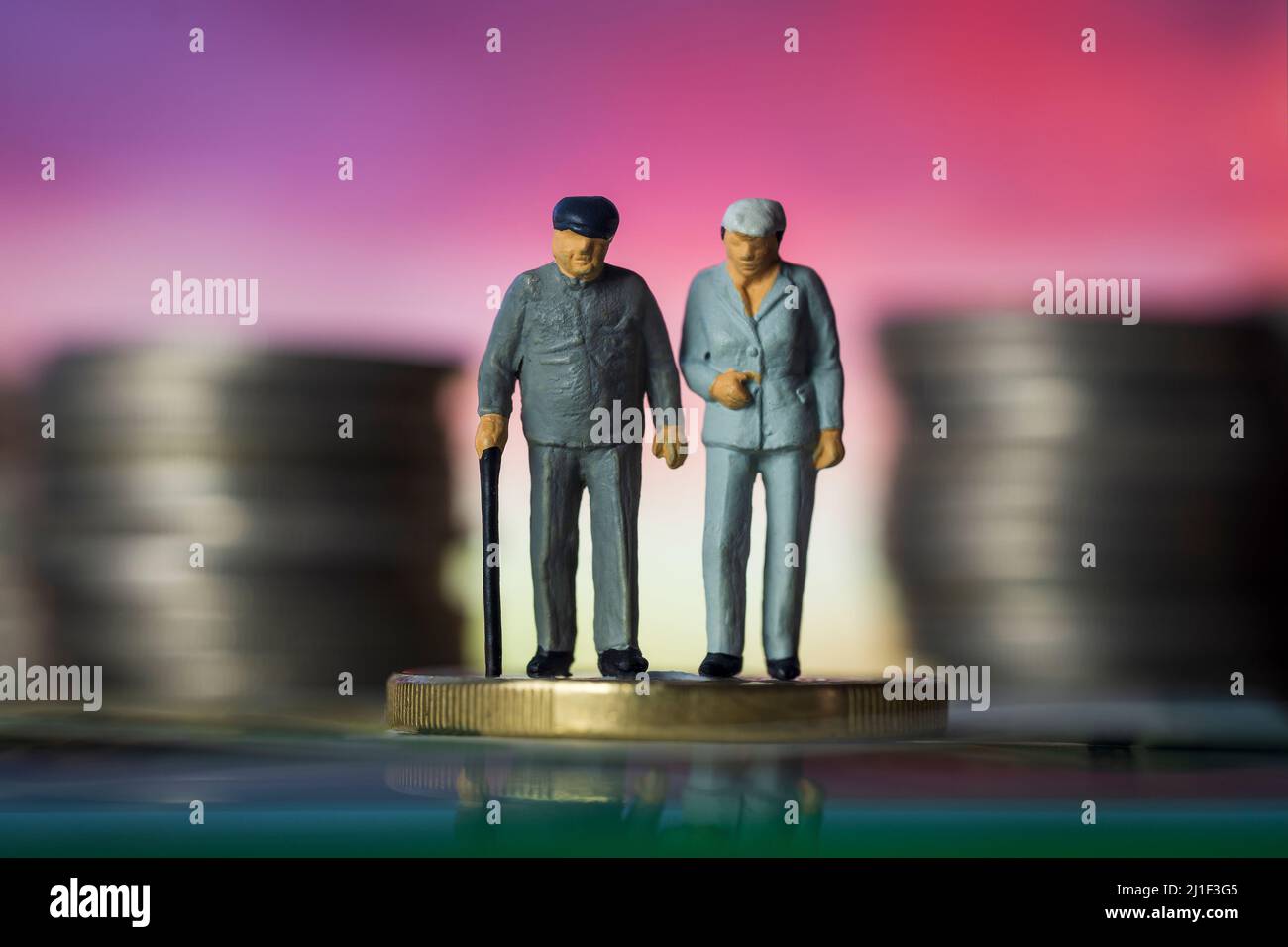 Miniature people old couple walking with a cane between coin stacks ...