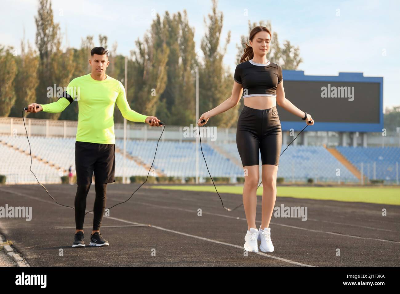 Sporty young couple with skipping ropes training in the stadium Stock ...