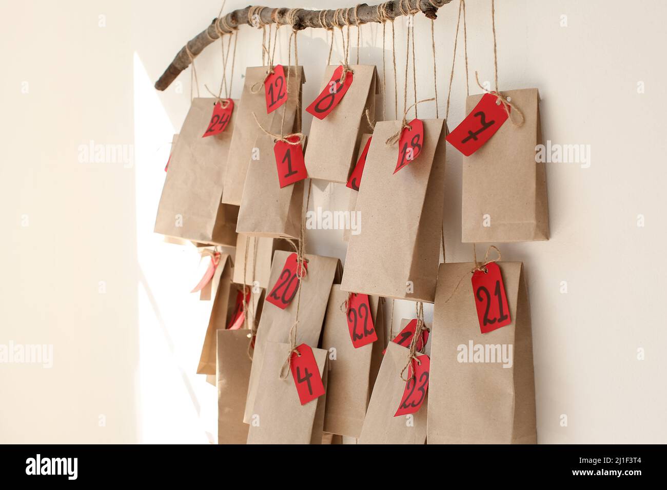 Stylish advent calendar hanging on white wall in room Stock Photo - Alamy