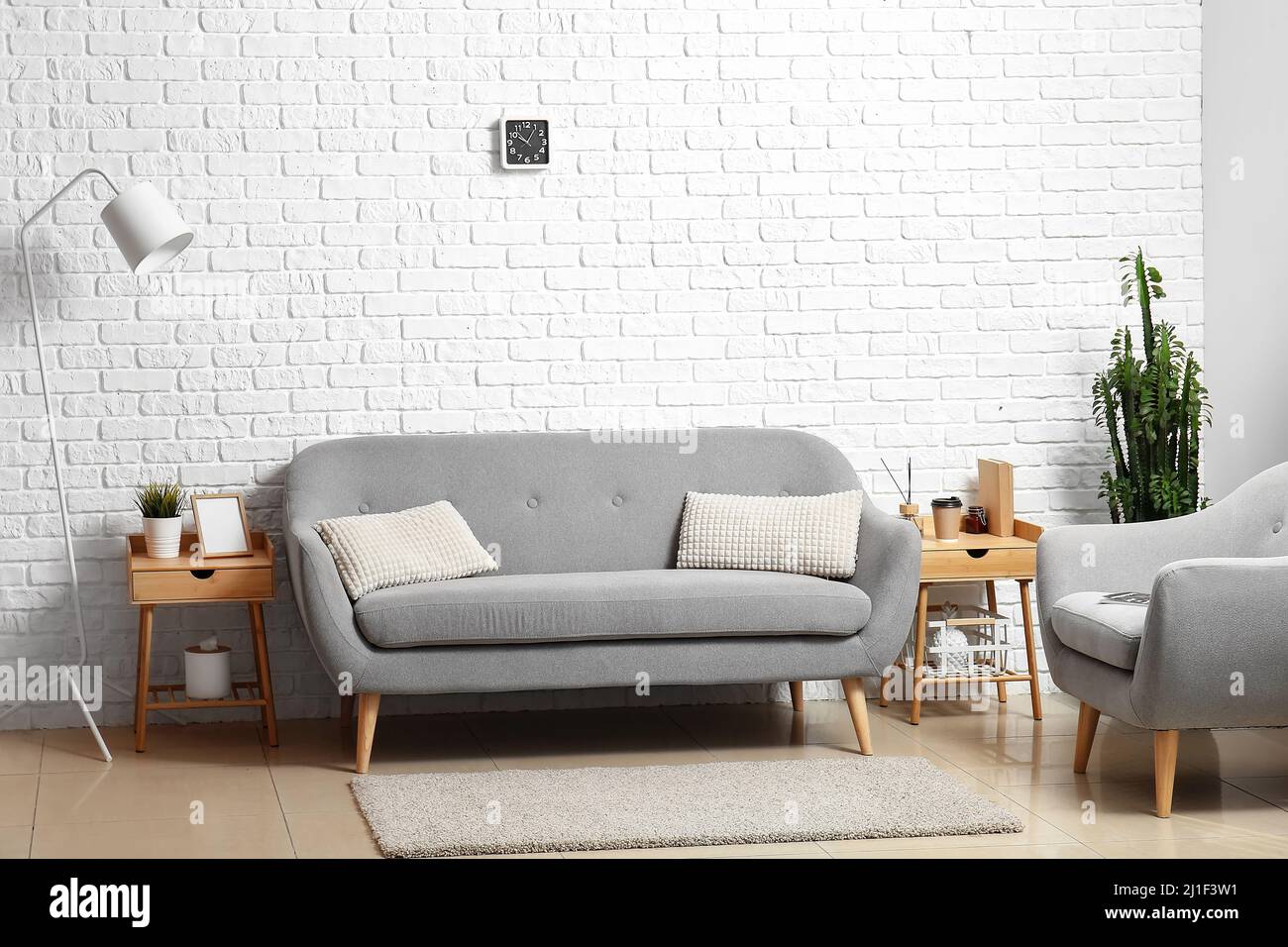 Modern interior of room with sofa, armchair and tables Stock Photo - Alamy