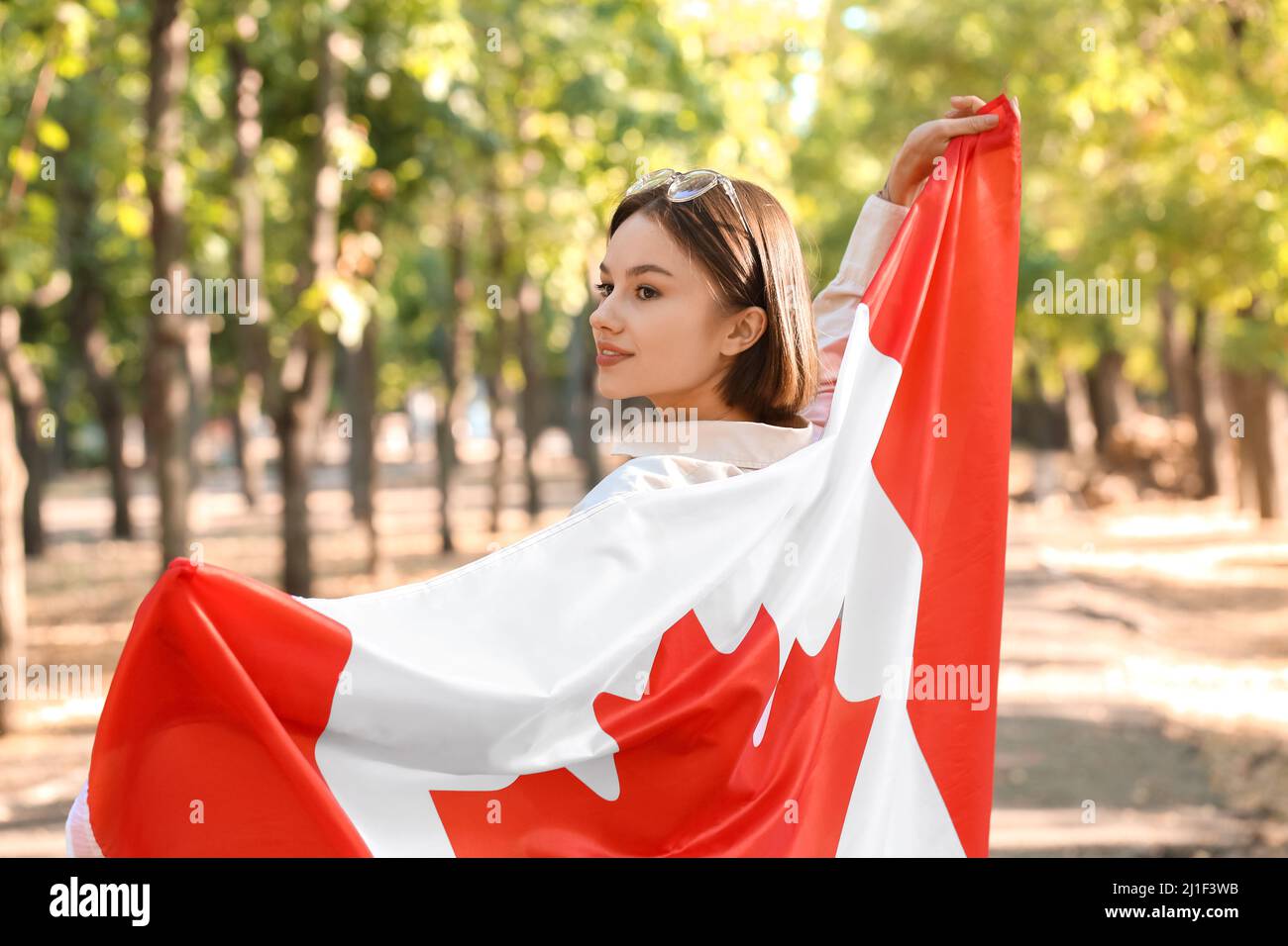 Beautiful young woman with flag of Canada outdoors Stock Photo - Alamy