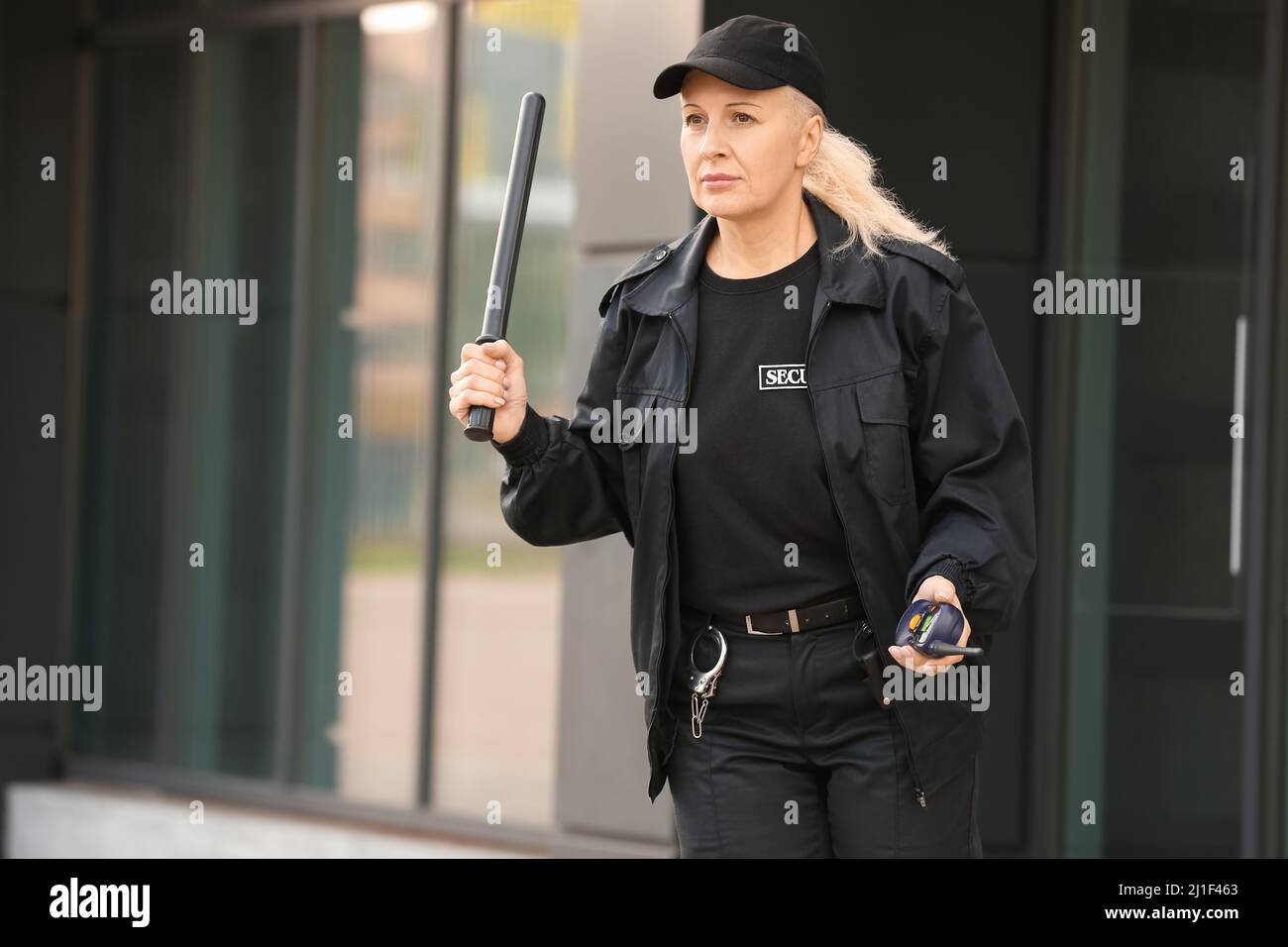 Female security guard with baton outdoors Stock Photo - Alamy