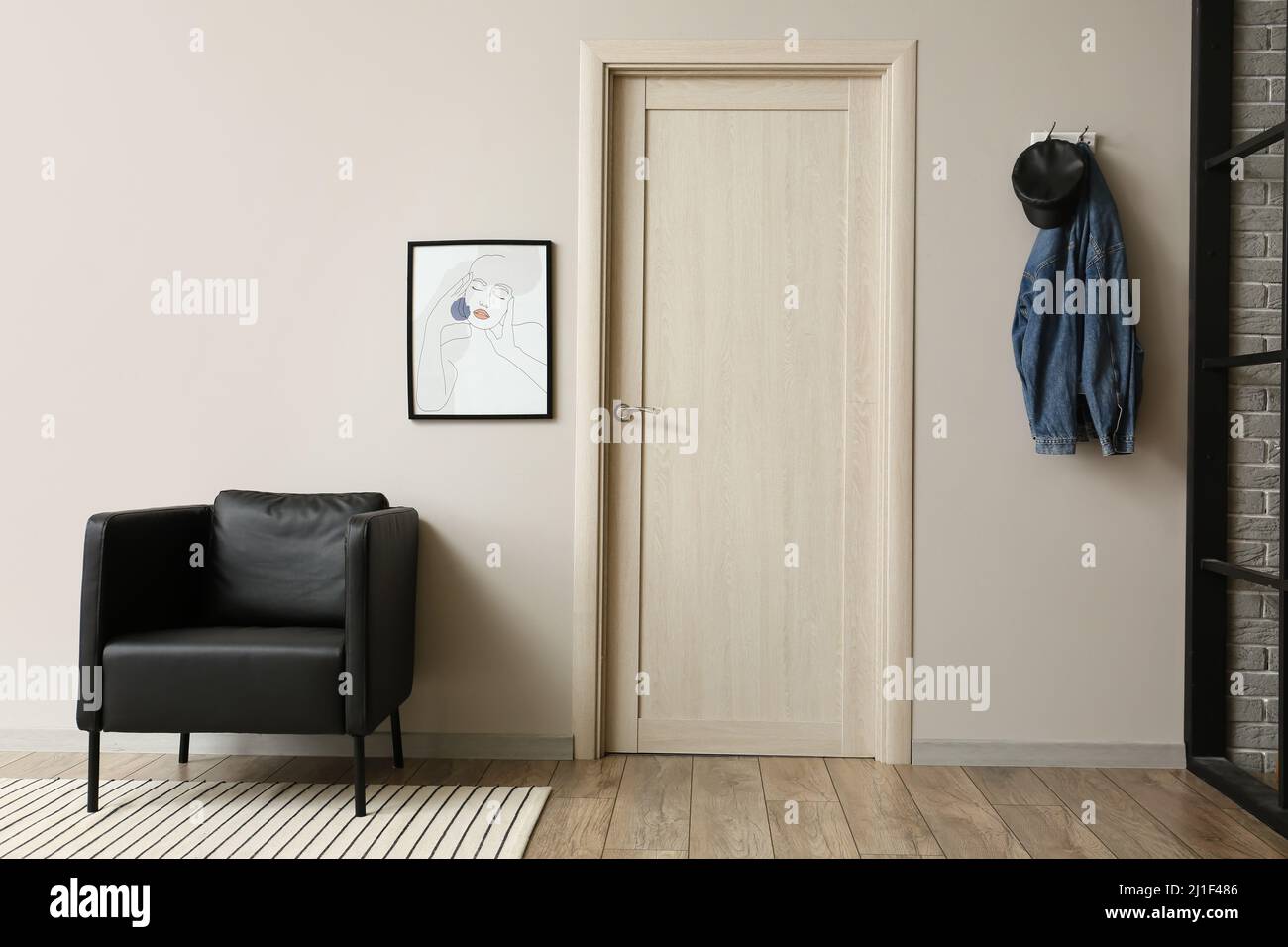 Interior of room with armchair near door Stock Photo - Alamy