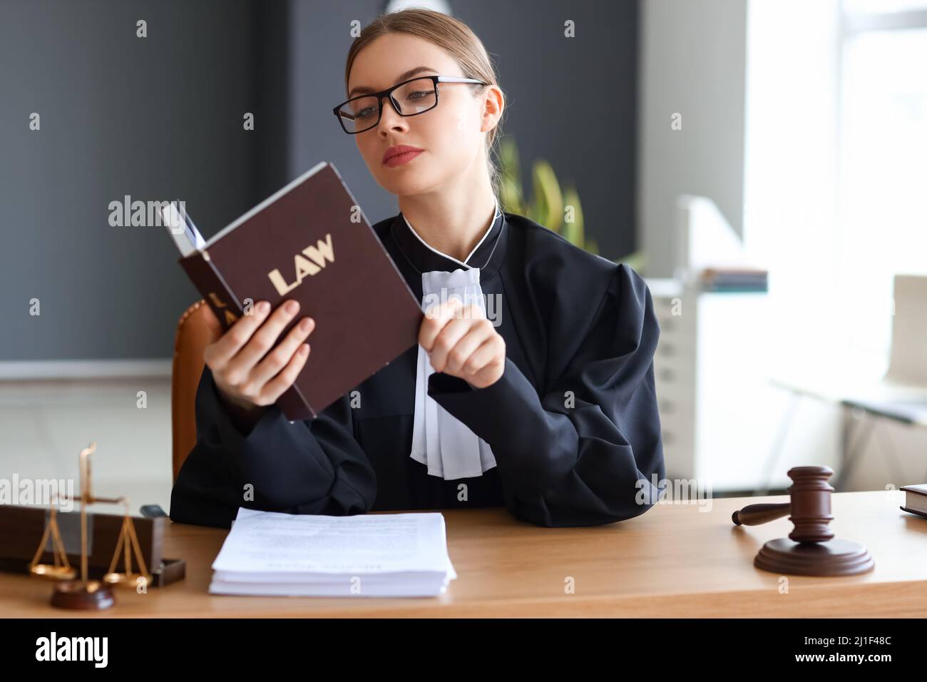 Female judge with book at workplace in courtroom Stock Photo - Alamy