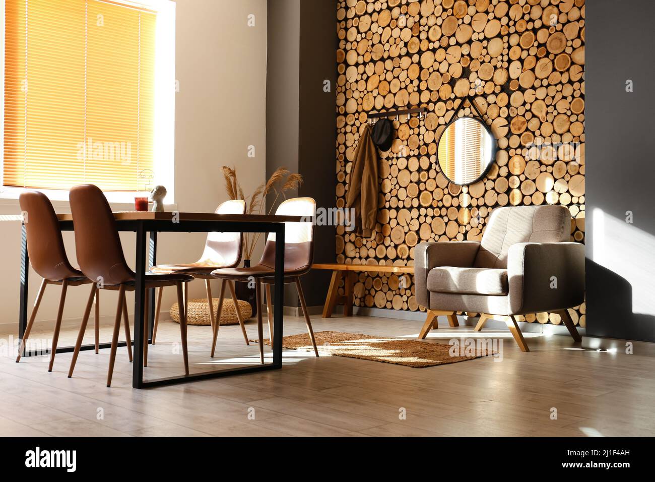 Interior of stylish dining room with table, clothes rack and armchair ...