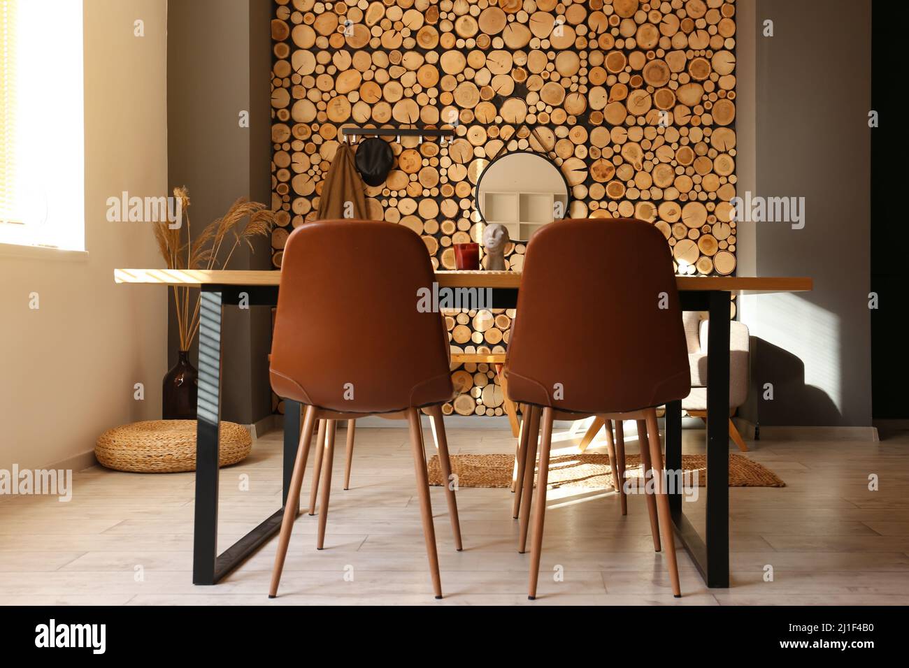 Interior of stylish dining room with table, clothes rack and wooden ...