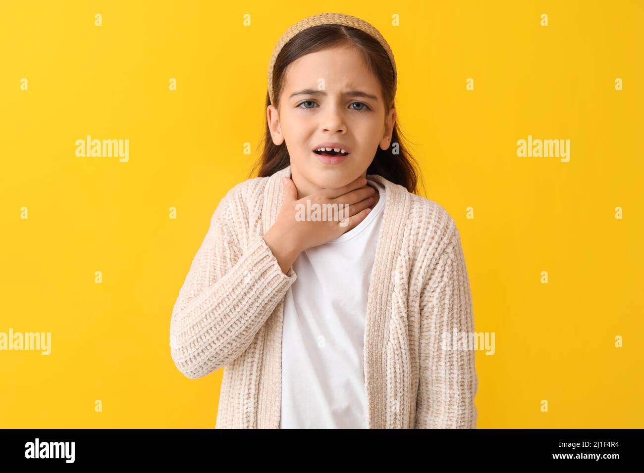 Little girl suffering from sore throat on yellow background Stock Photo ...