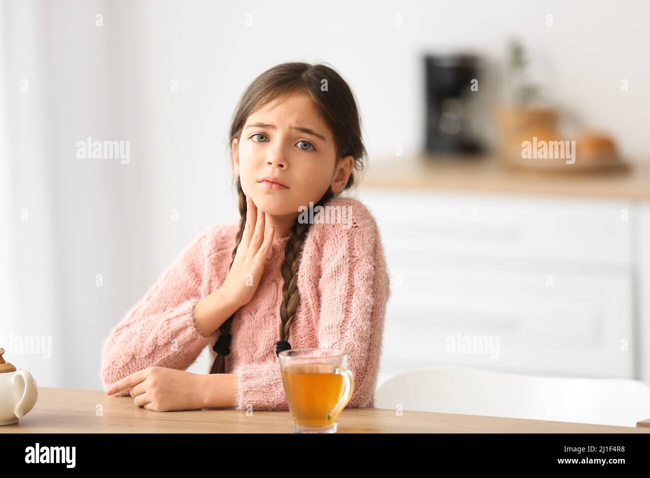 Sad little girl suffering from sore throat in kitchen Stock Photo - Alamy