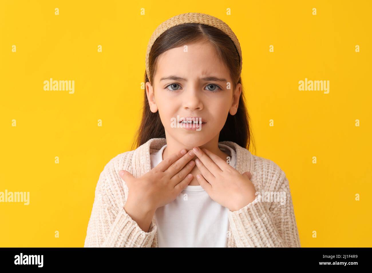 Little girl suffering from sore throat on yellow background Stock Photo ...