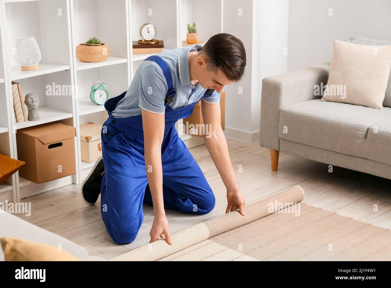 Male worker rolling carpet hi-res stock photography and images - Alamy