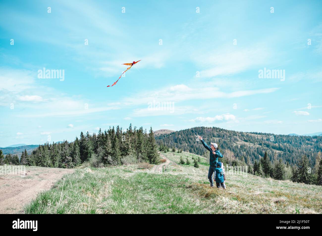 man with kids playing outdoors with kite catching wind. having fun ...