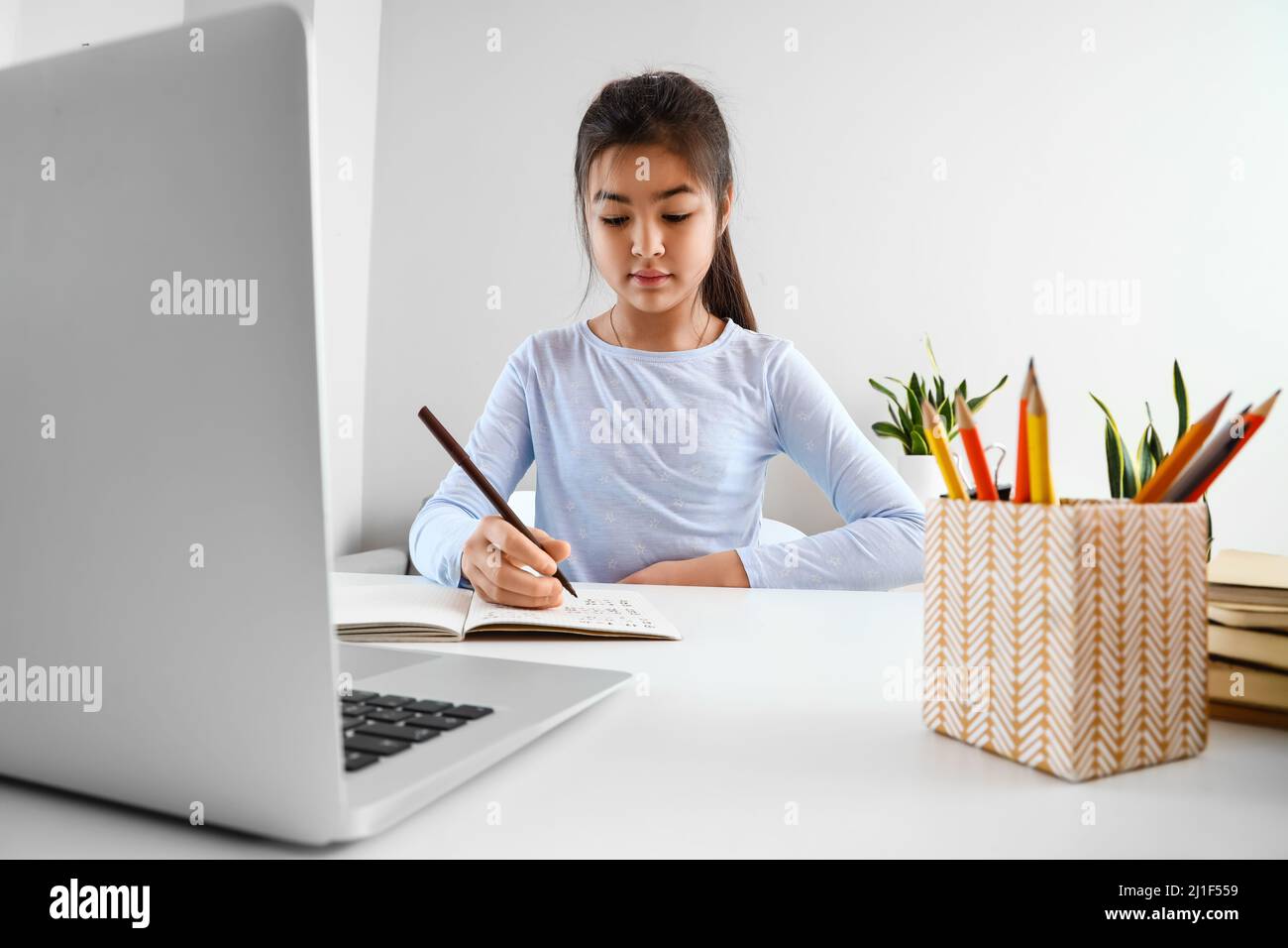 Little Asian girl studying Math online at home Stock Photo - Alamy