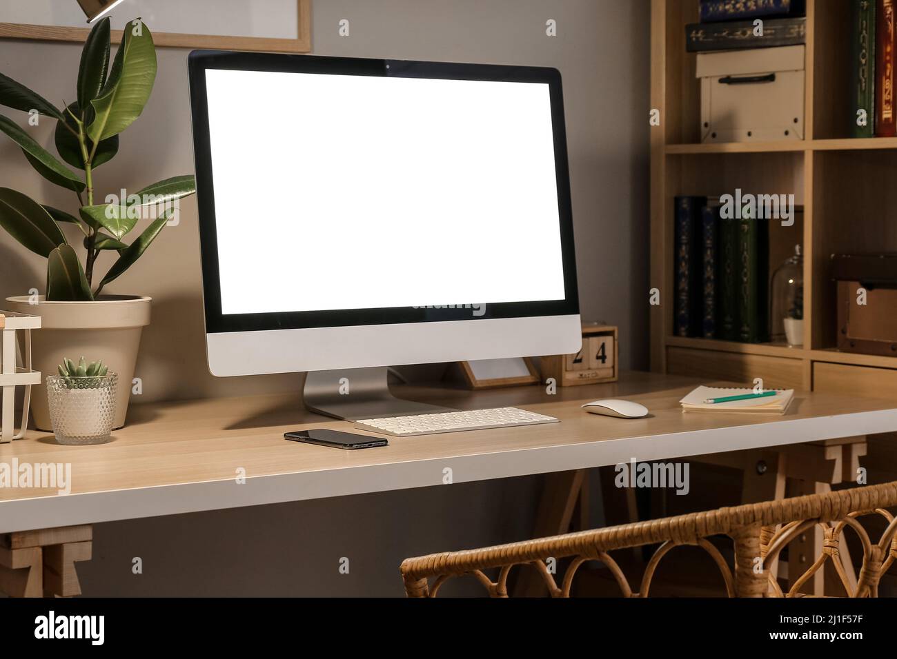 Workplace with modern computer, mobile phone and houseplant near grey ...