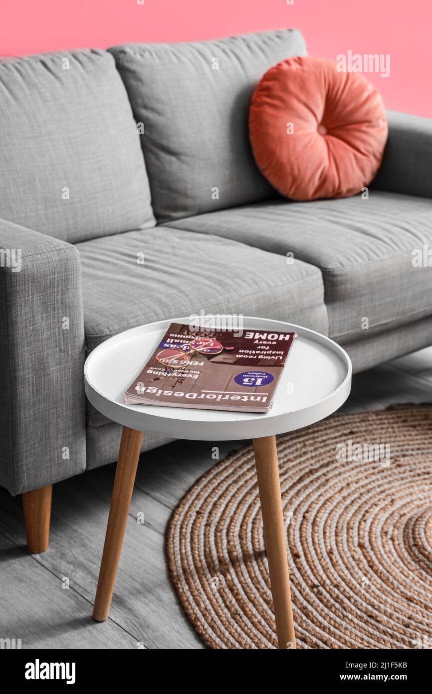 Magazine on table near sofa in stylish room Stock Photo - Alamy