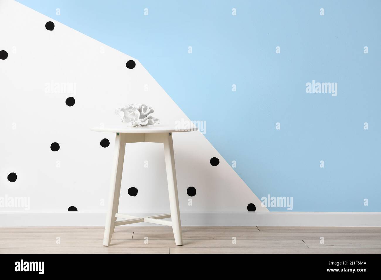 Table with stylish decor near color wall Stock Photo - Alamy